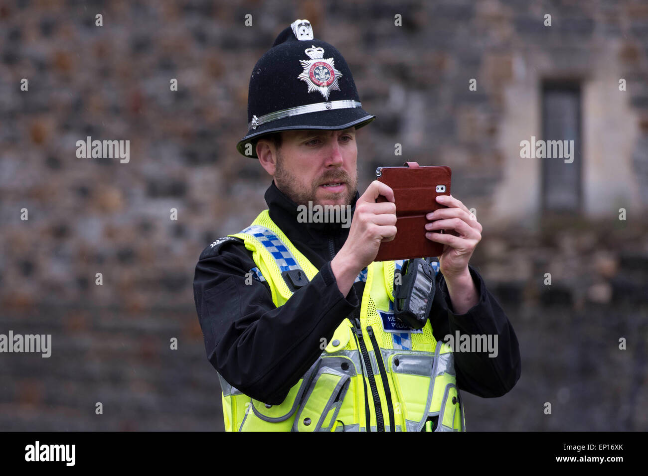 A policeman seen taking a picture on a mobile phone Stock Photo - Alamy