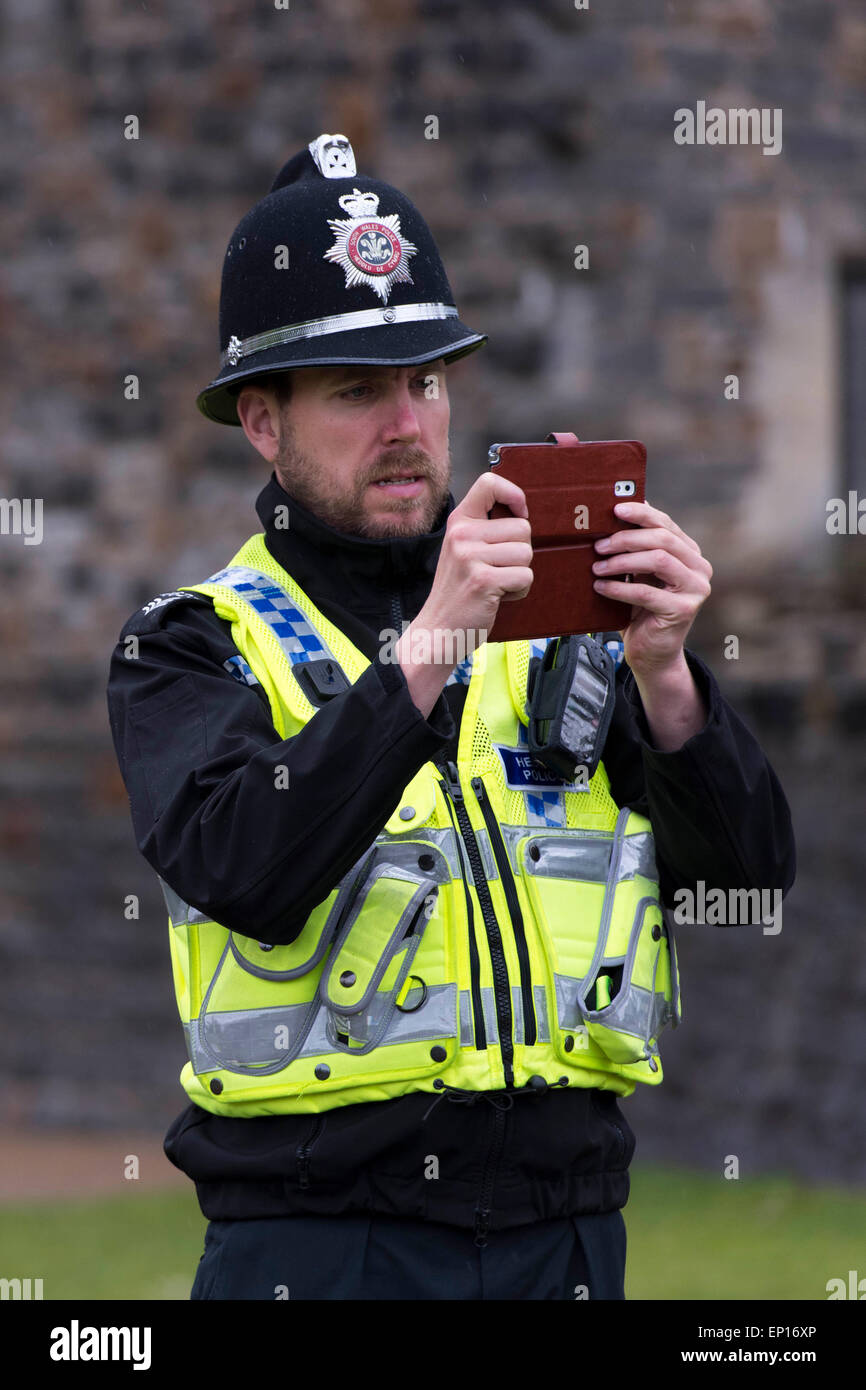 A policeman seen taking a picture on a mobile phone Stock Photo - Alamy
