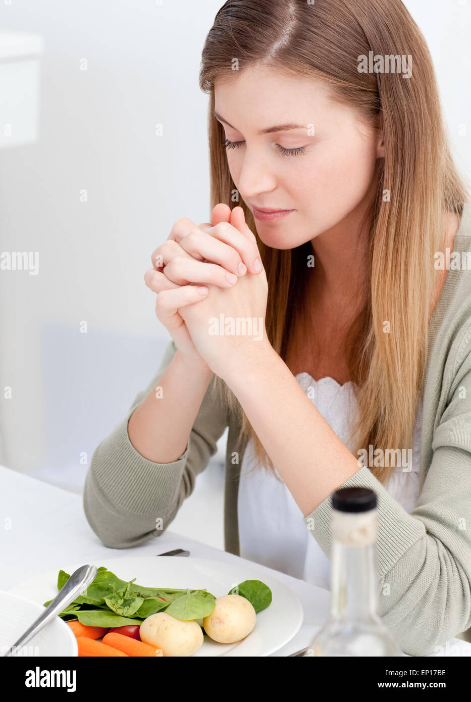 Woman praying at the table Stock Photo - Alamy