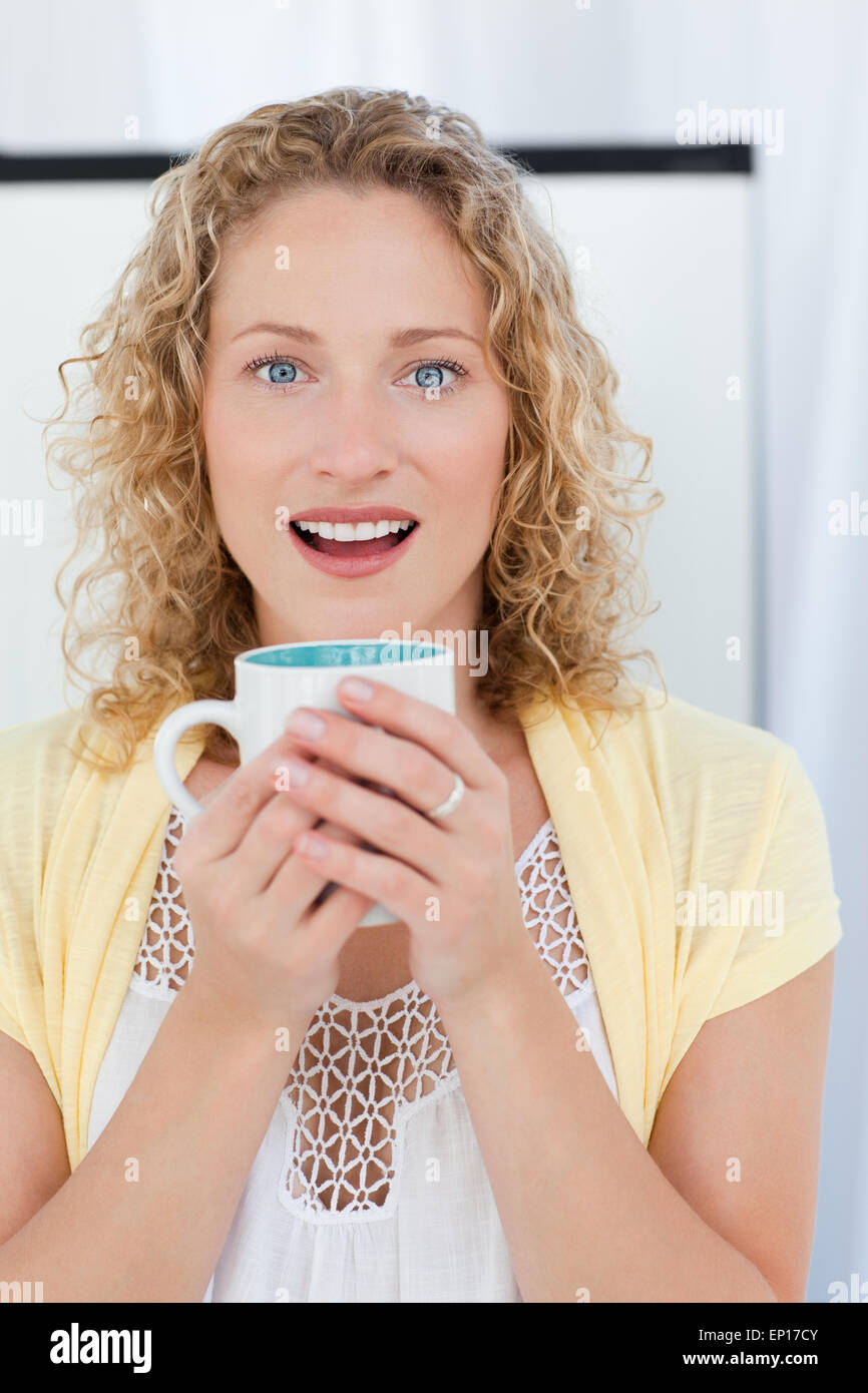 Pretty woman drinking tea in her kitchen Stock Photo - Alamy