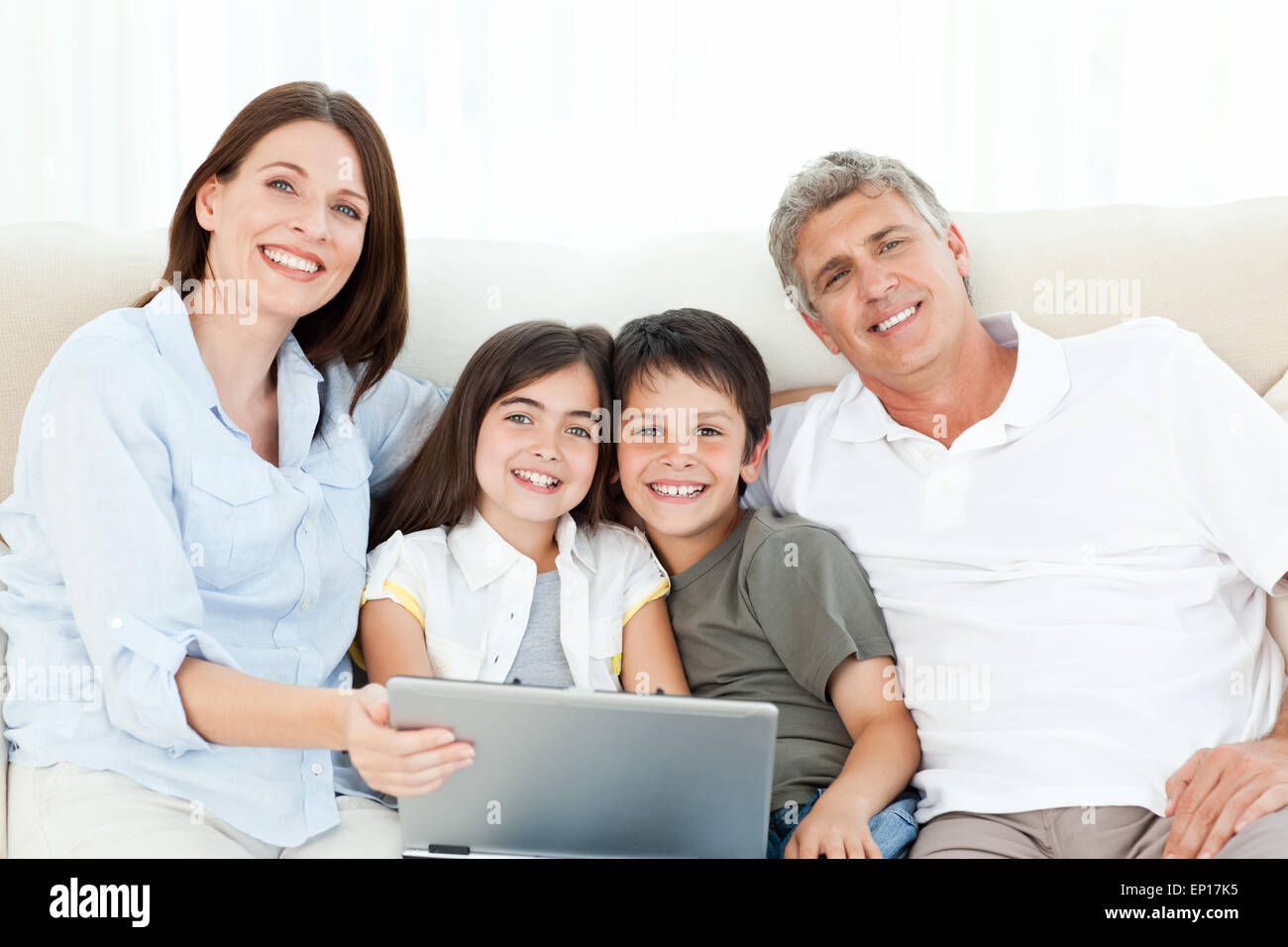 Pretty family looking at the camera at home Stock Photo - Alamy
