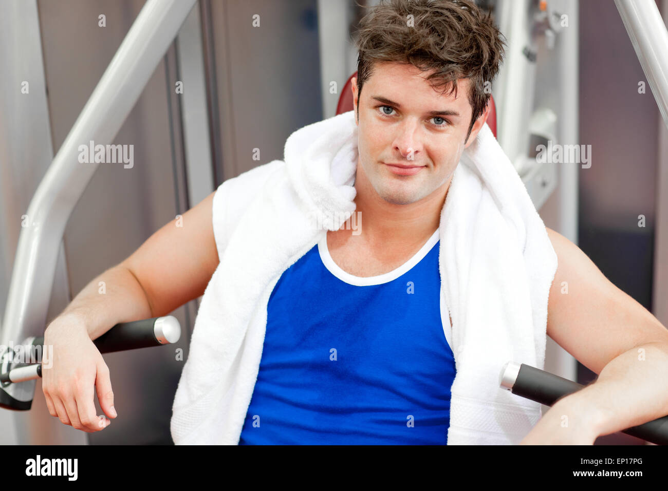 Confident young man with a towel using a bench press Stock Photo - Alamy