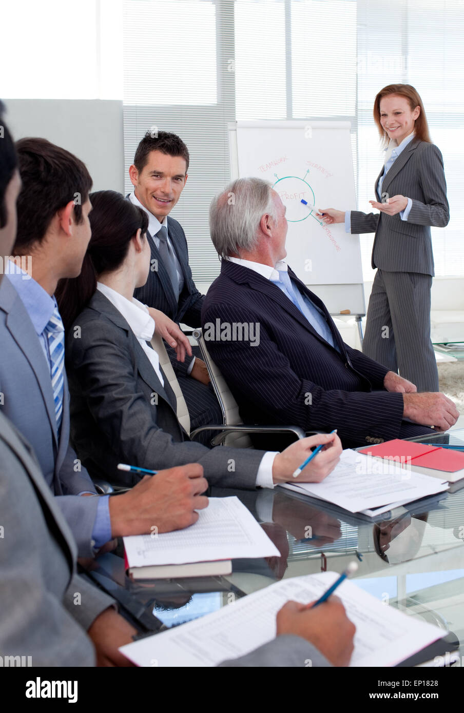 Smiling manager giving a presentation to her team Stock Photo - Alamy