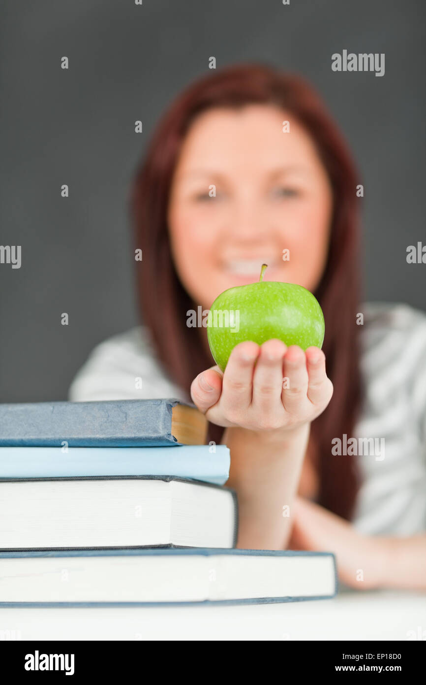 Portrait of a beautiful student showing an apple Stock Photo - Alamy