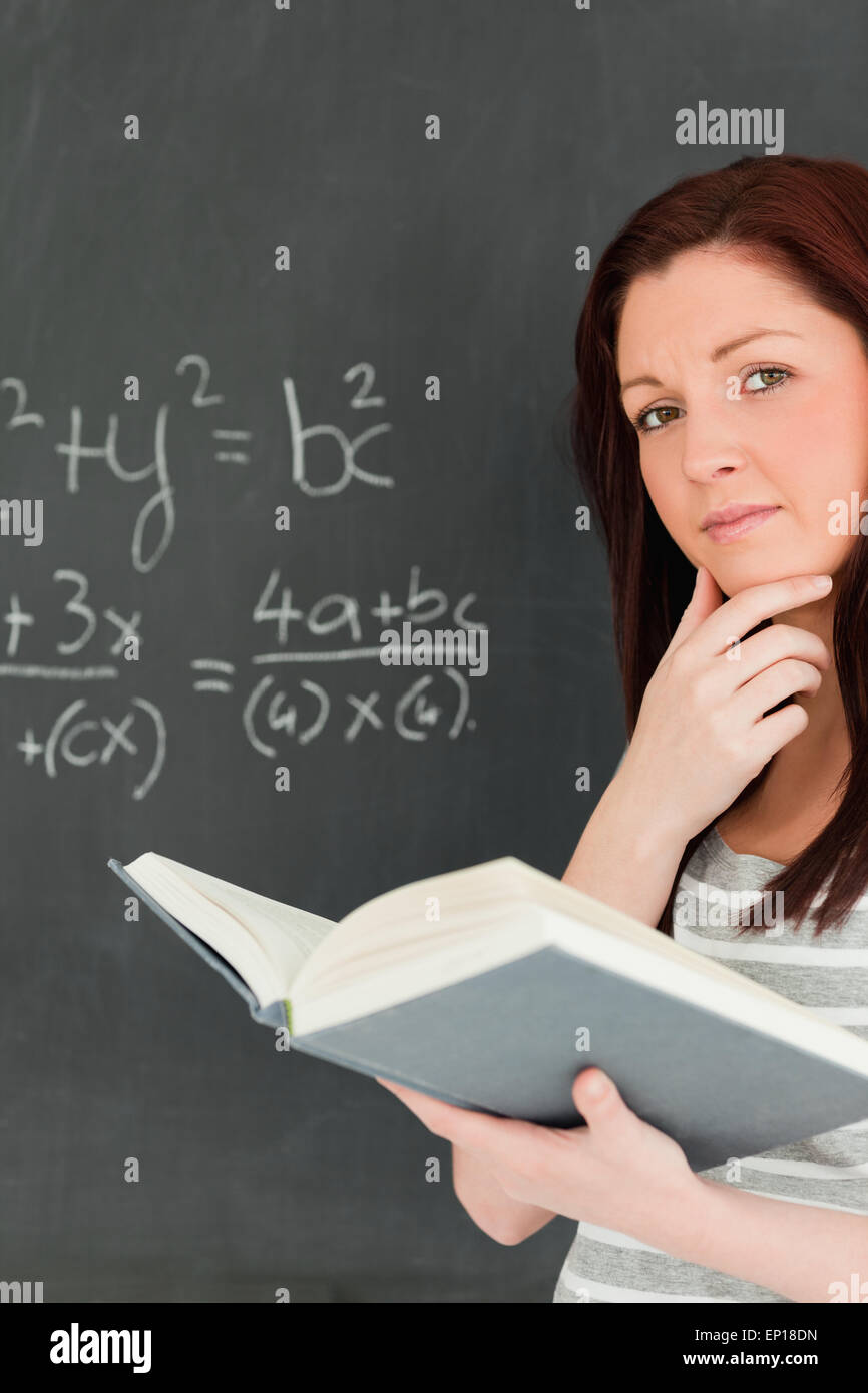 Portrait of a cute woman trying to solve an equation Stock Photo - Alamy