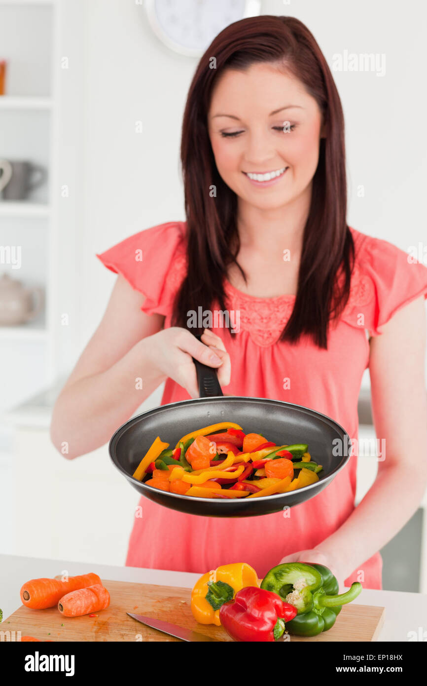 Attractive red-haired woman cooking vegetables in the kitchen Stock ...