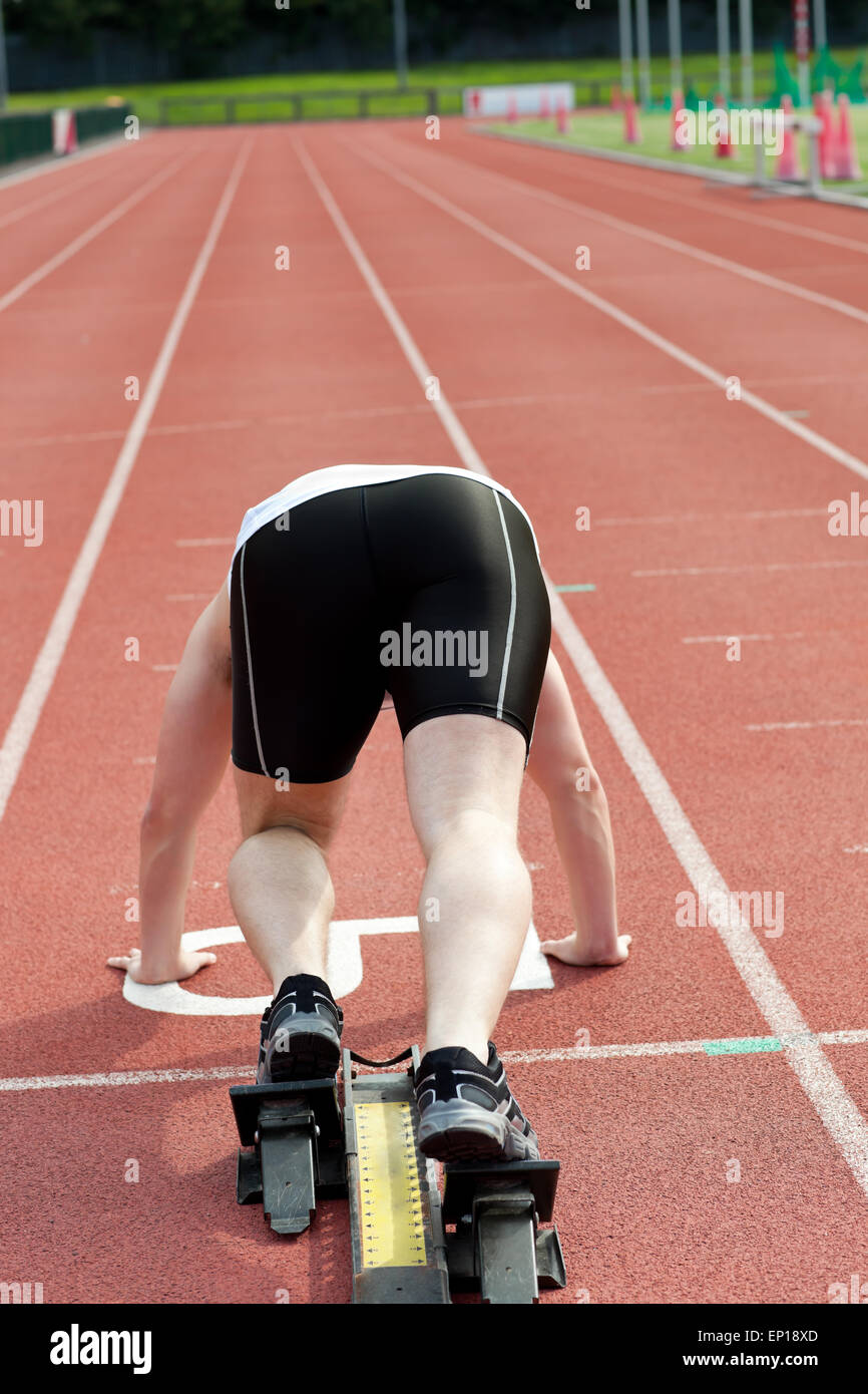 Sporty man waiting in starting block in a stadium Stock Photo - Alamy