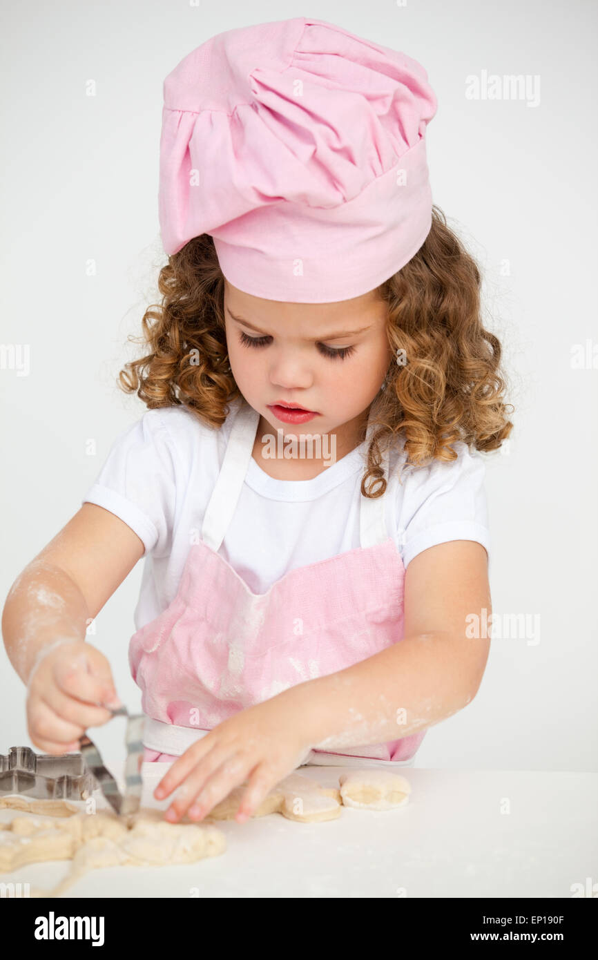Cute little girl making biscuit at a table Stock Photo - Alamy