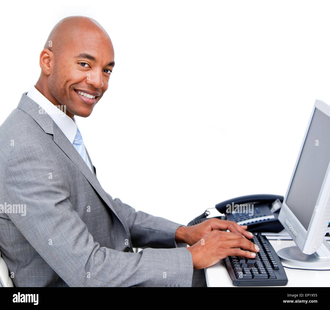 Handsome businessman working at a computer against a white background ...