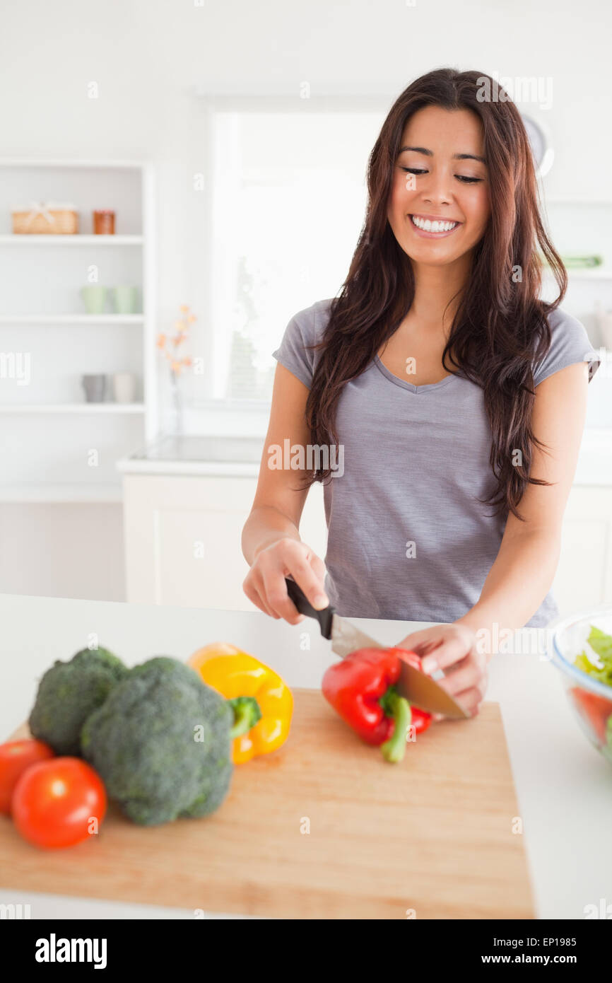 Good looking female cooking vegetables while standing Stock Photo - Alamy