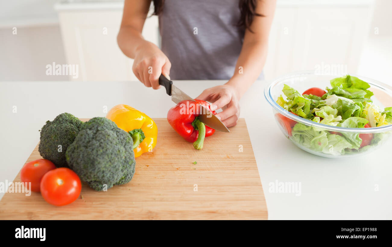 Young female cooking vegetables while standing Stock Photo - Alamy