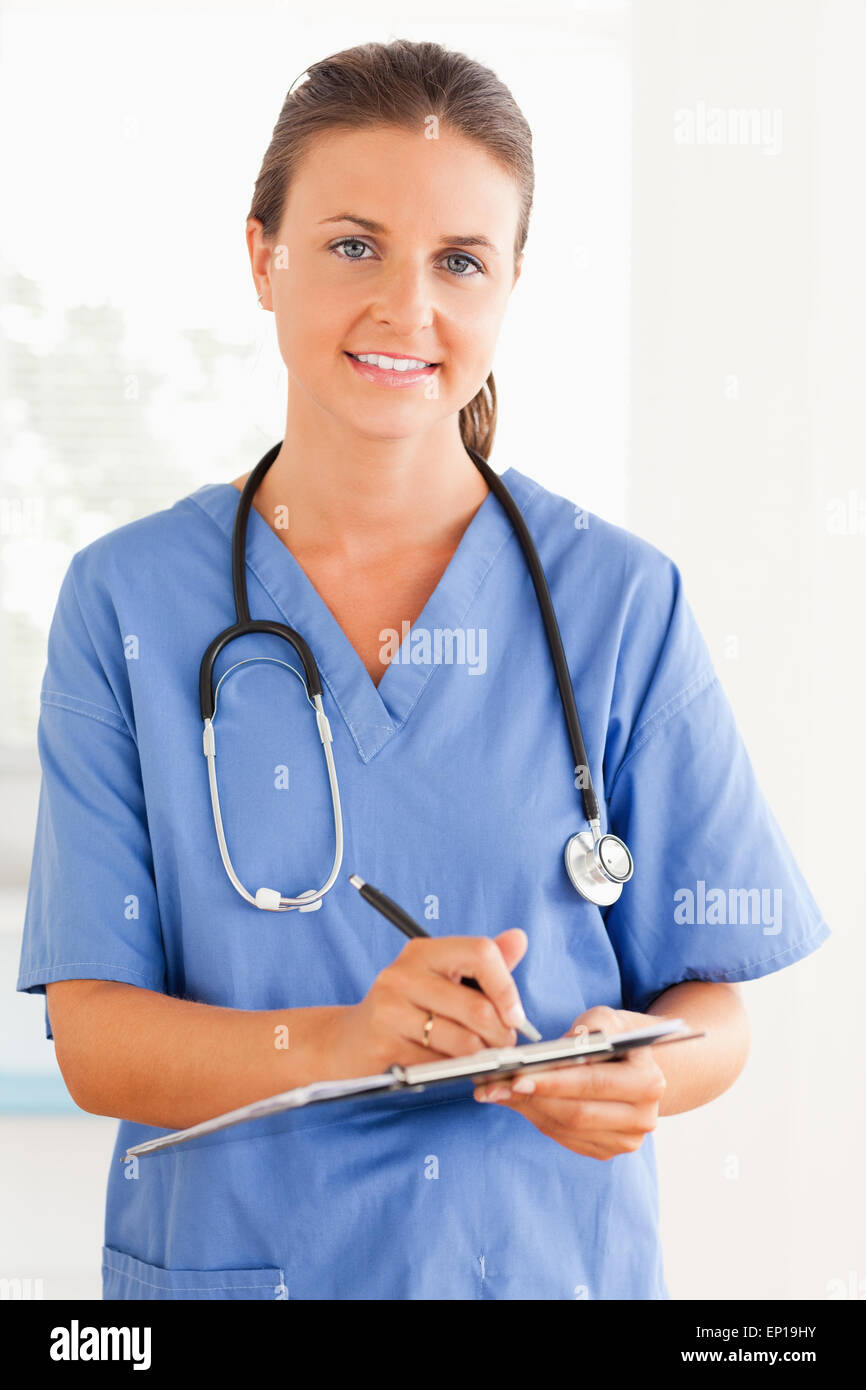 Nurse writing in a folder Stock Photo - Alamy