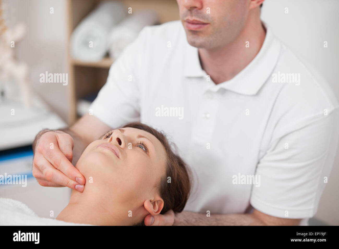 Physiotherapist pressing two fingers on the neck of his patient Stock ...