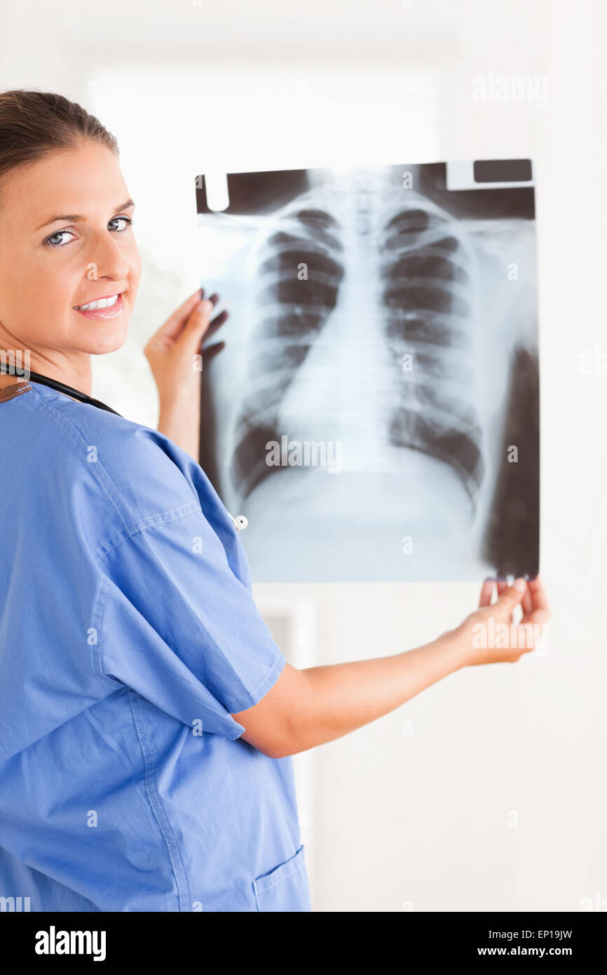 Charming doctor smiling into the camera holding a x-ray Stock Photo - Alamy