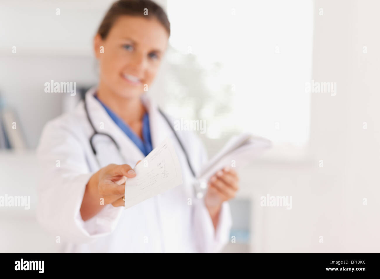 Smiling doctor handing out a prescription Stock Photo - Alamy