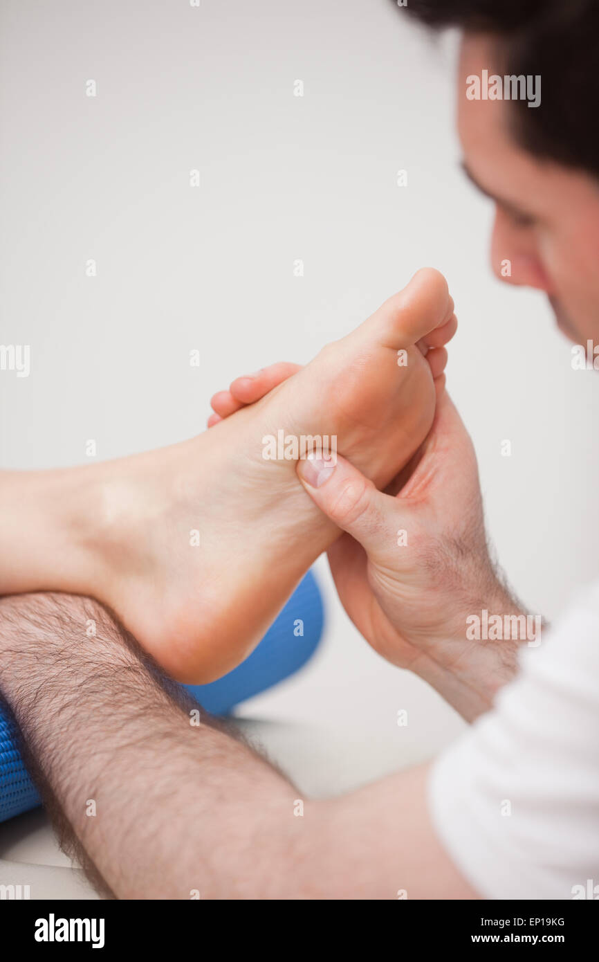 Reflexologist massaging the foot of his patient Stock Photo - Alamy