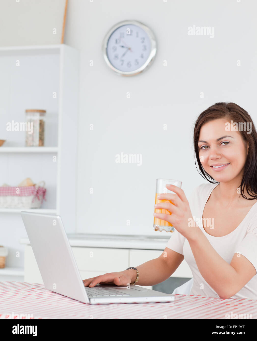 Portrait of a brunette using her laptop and drinking juice Stock Photo ...