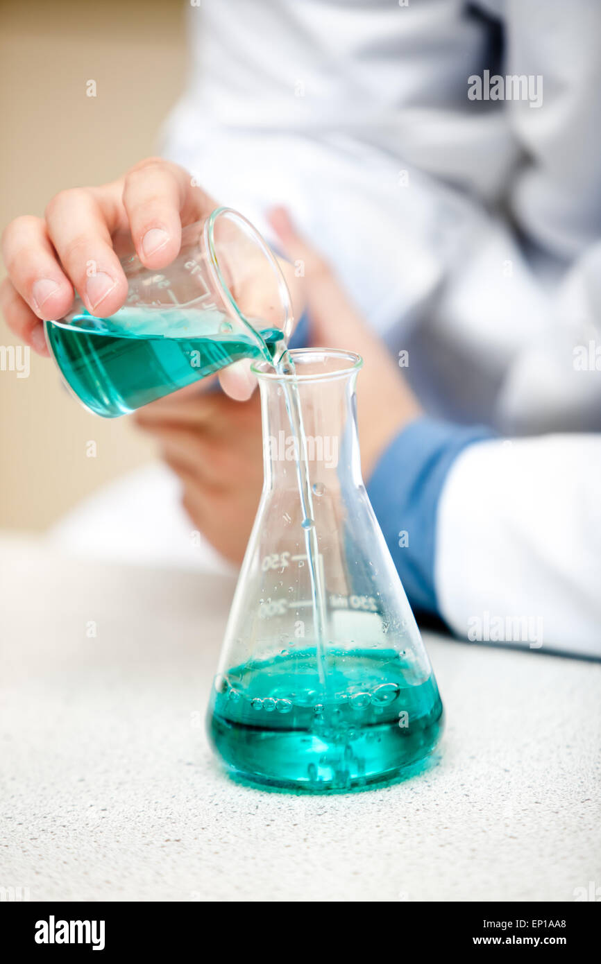 Male chemist pouring a blue liquid Stock Photo - Alamy