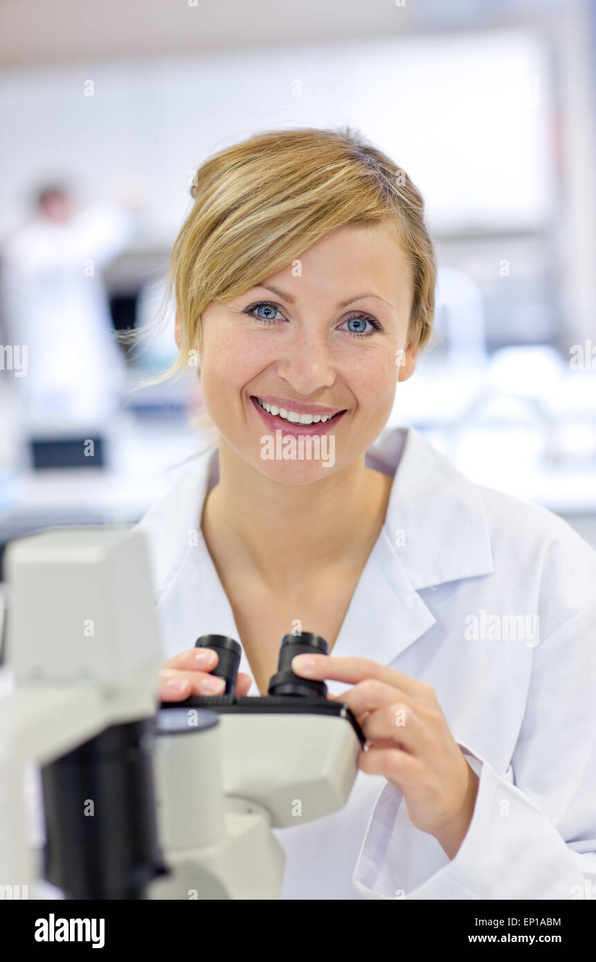 Joyful female scientist using a microscope Stock Photo - Alamy
