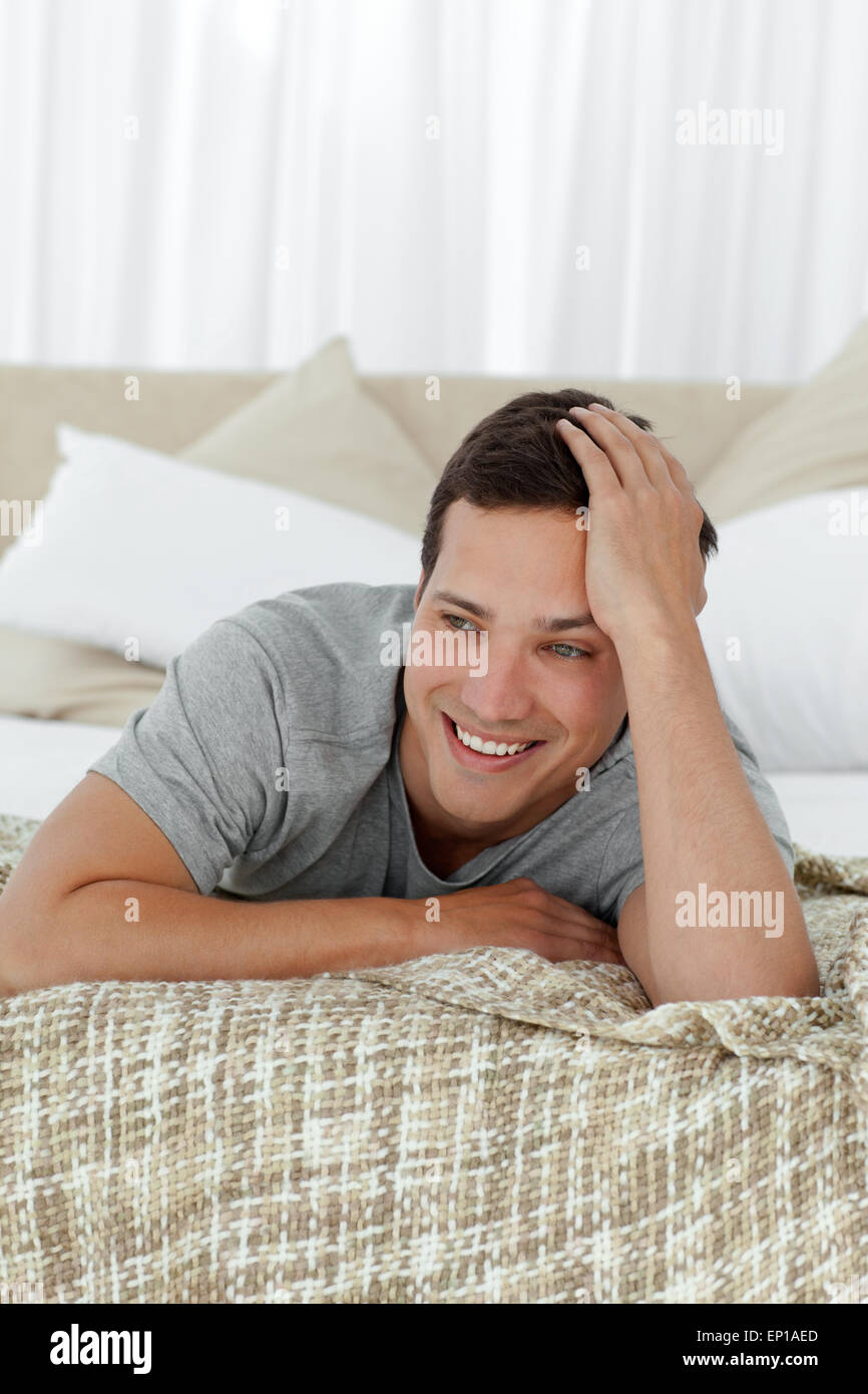 Happy man smiling lying on his bed Stock Photo - Alamy