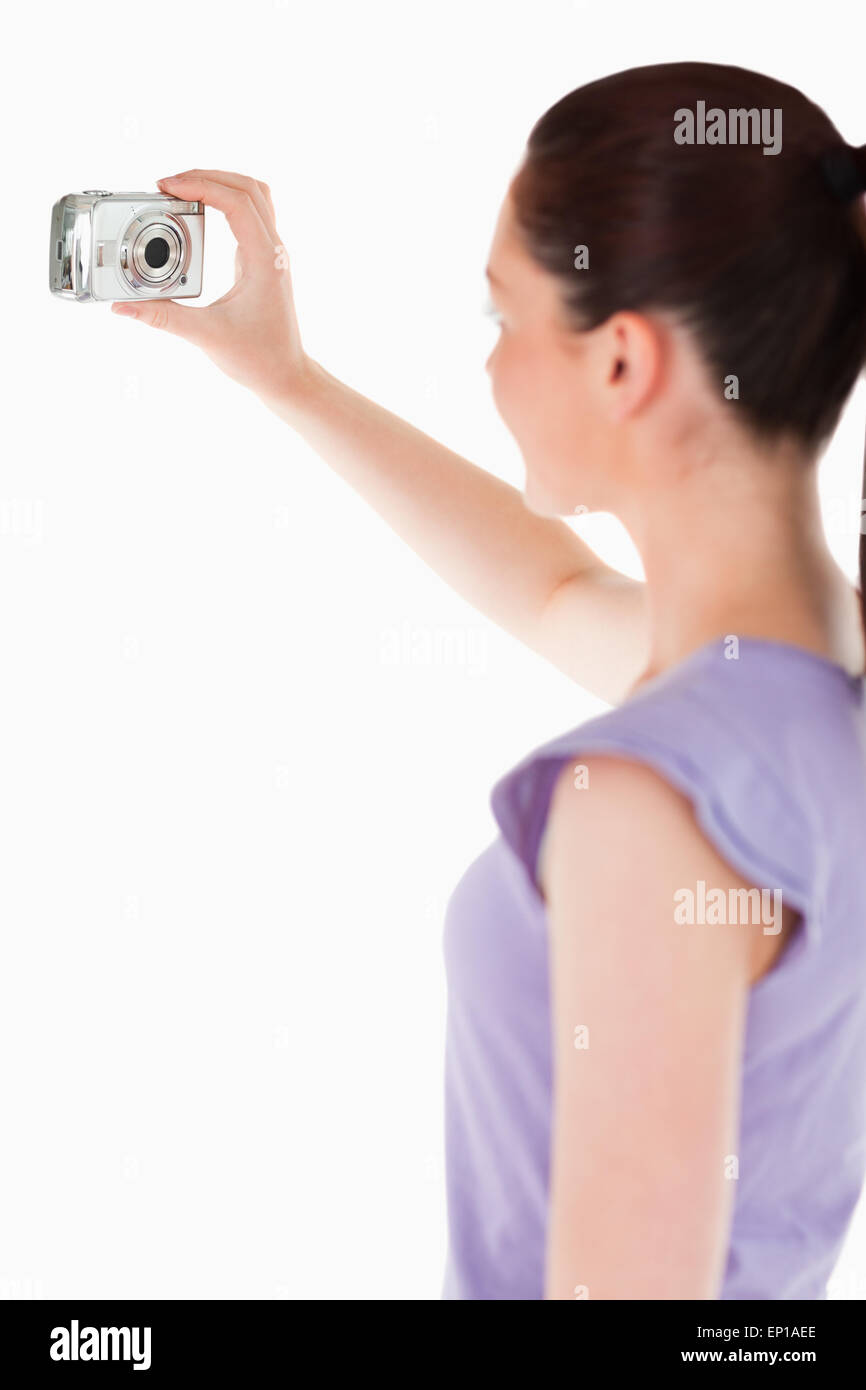 Pretty woman using a camera while standing Stock Photo - Alamy