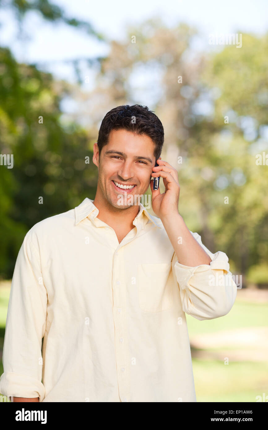 Handsome man phoning in the park Stock Photo - Alamy