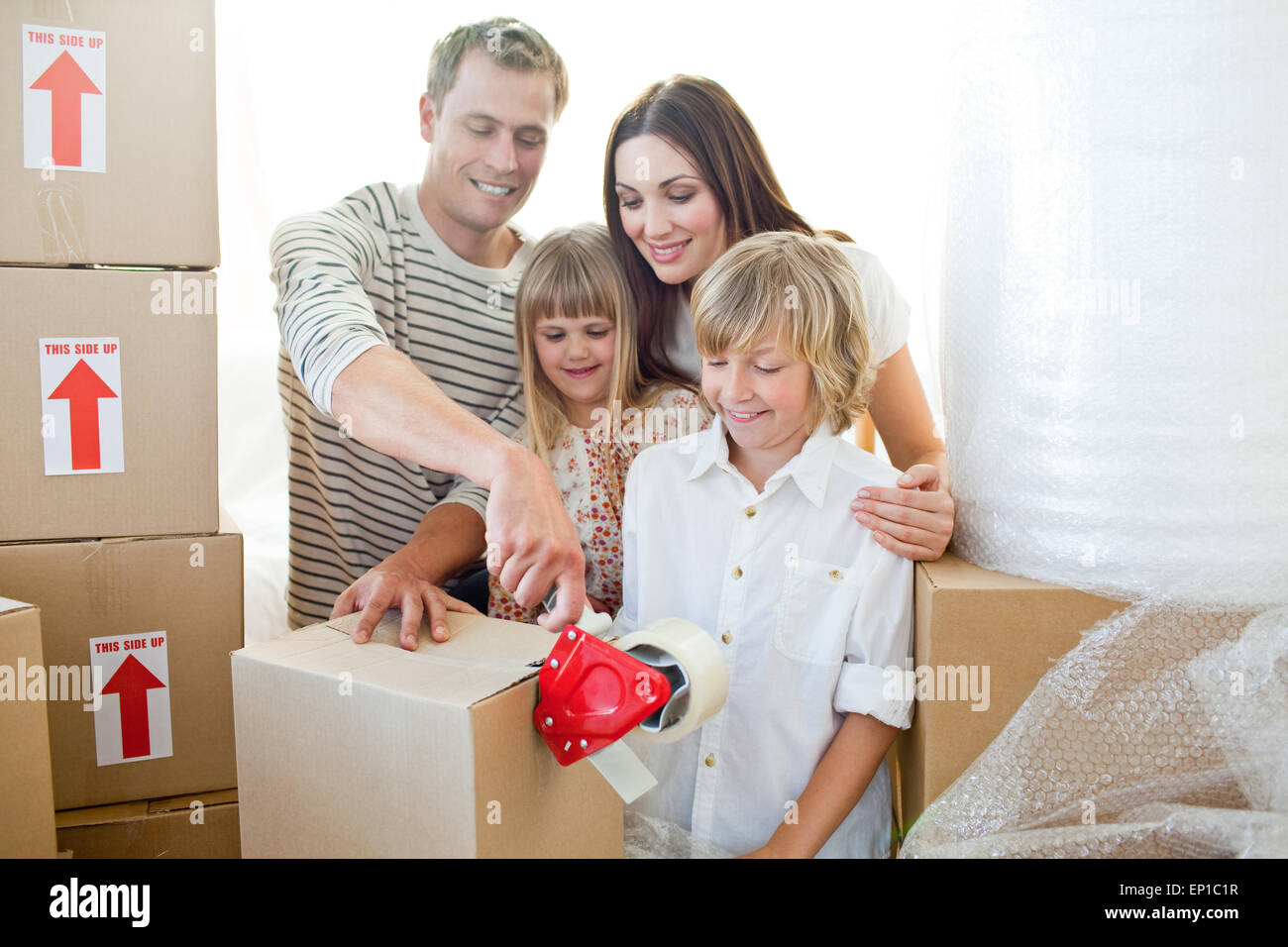 Merry family packing boxes Stock Photo - Alamy