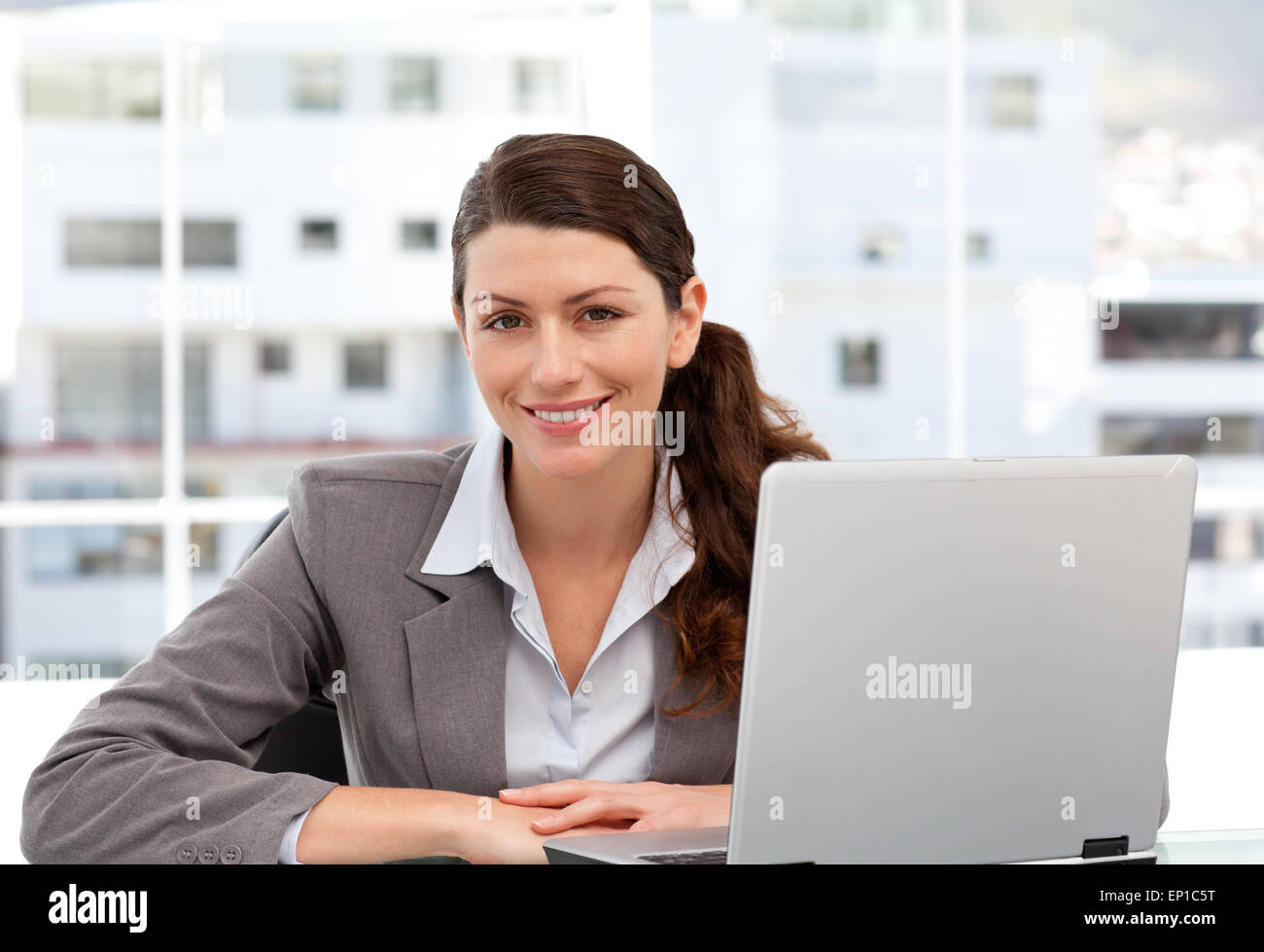 Smiling woman on the computer looking at the camera Stock Photo - Alamy