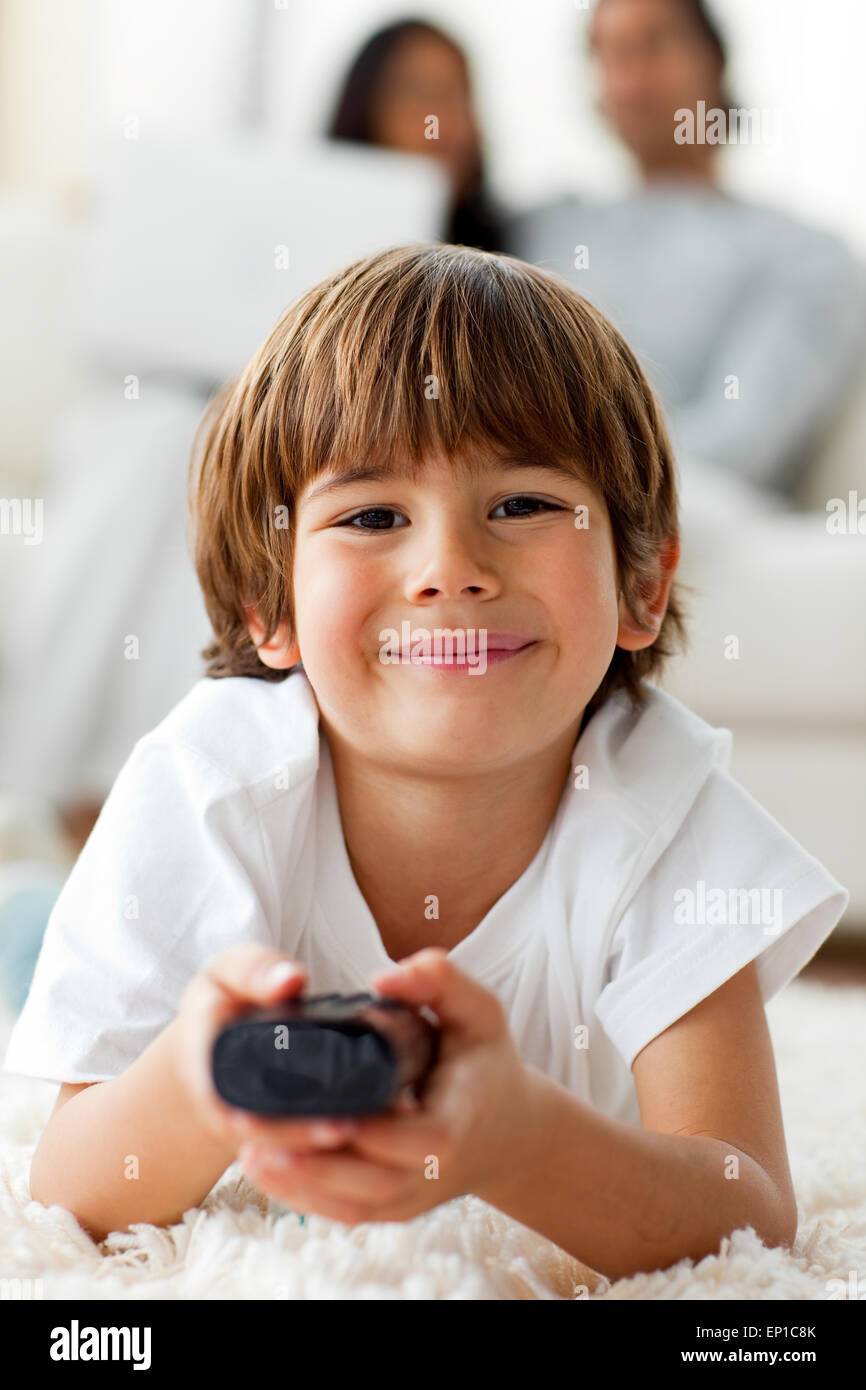 Adorable little boy watching TV lying on the floor Stock Photo - Alamy