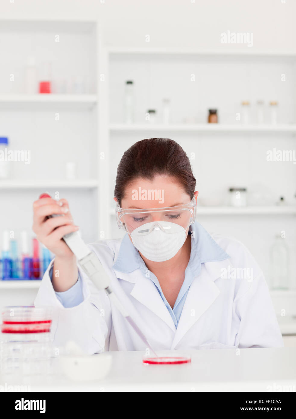 Portrait of a beautiful scientist preparing a sample wearing a sample ...