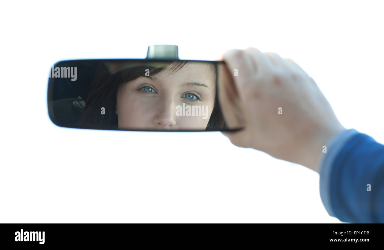 Brunette woman looking in the rear-view mirror Stock Photo - Alamy