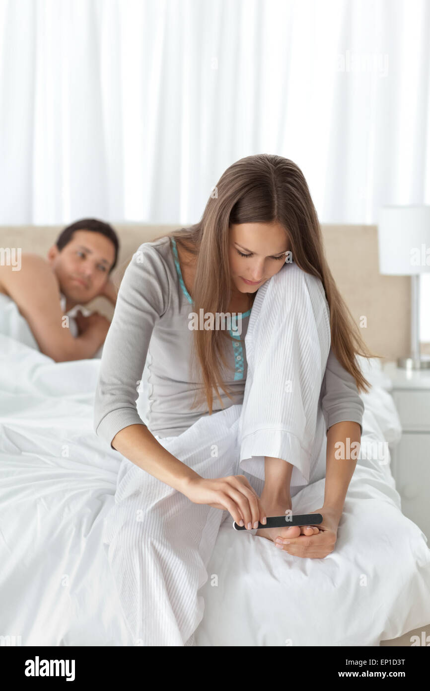 Man waiting for his girlfriend filing her toenails on the bed Stock ...