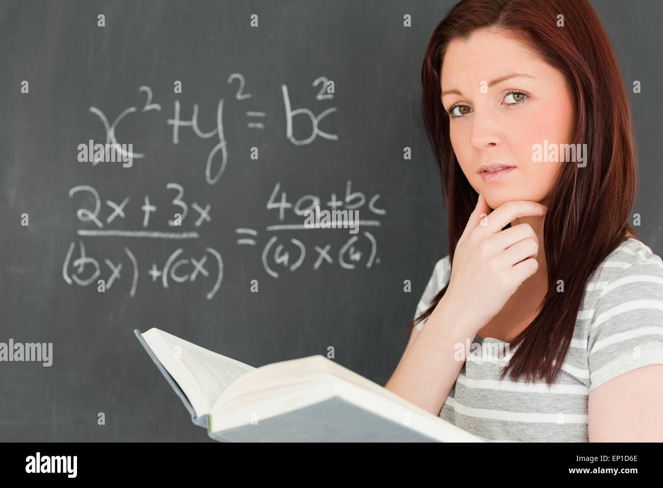 Reflective young woman trying to solve an equation Stock Photo - Alamy