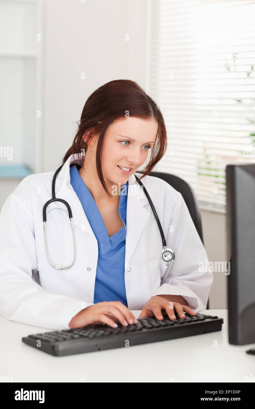 Female doctor typing on keyboard in office Stock Photo - Alamy