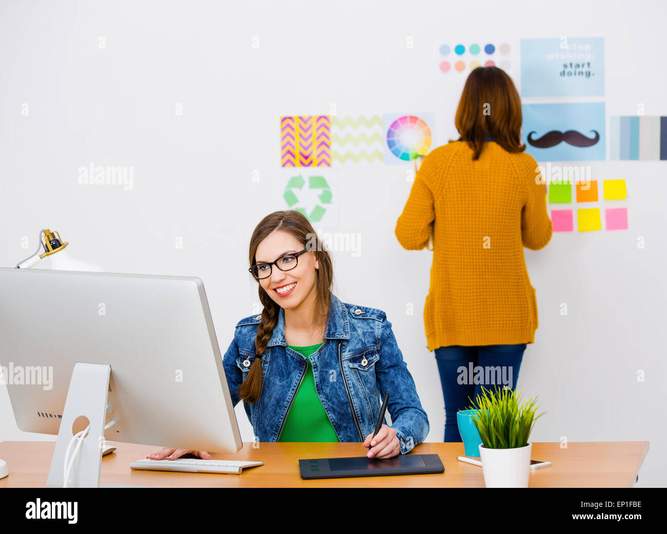Women working at desk In a creative office, team work Stock Photo - Alamy