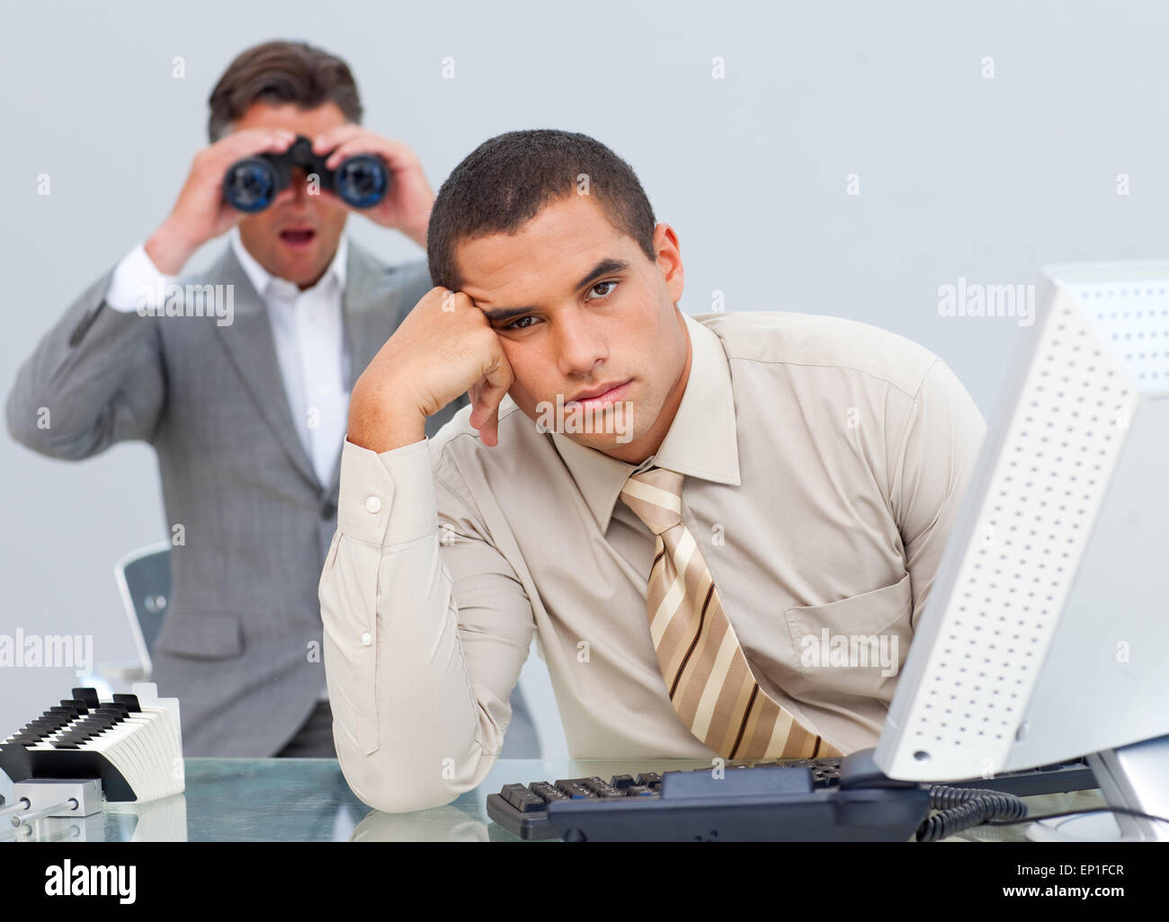 Handsome businessman getting bored and his manager looking through ...