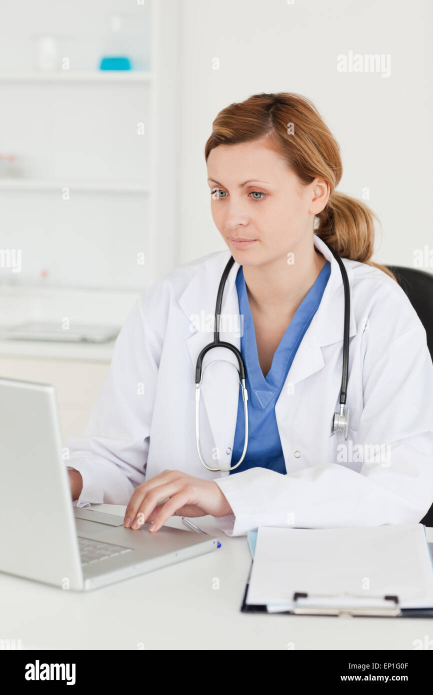 Concentrated doctor working on her laptop Stock Photo - Alamy