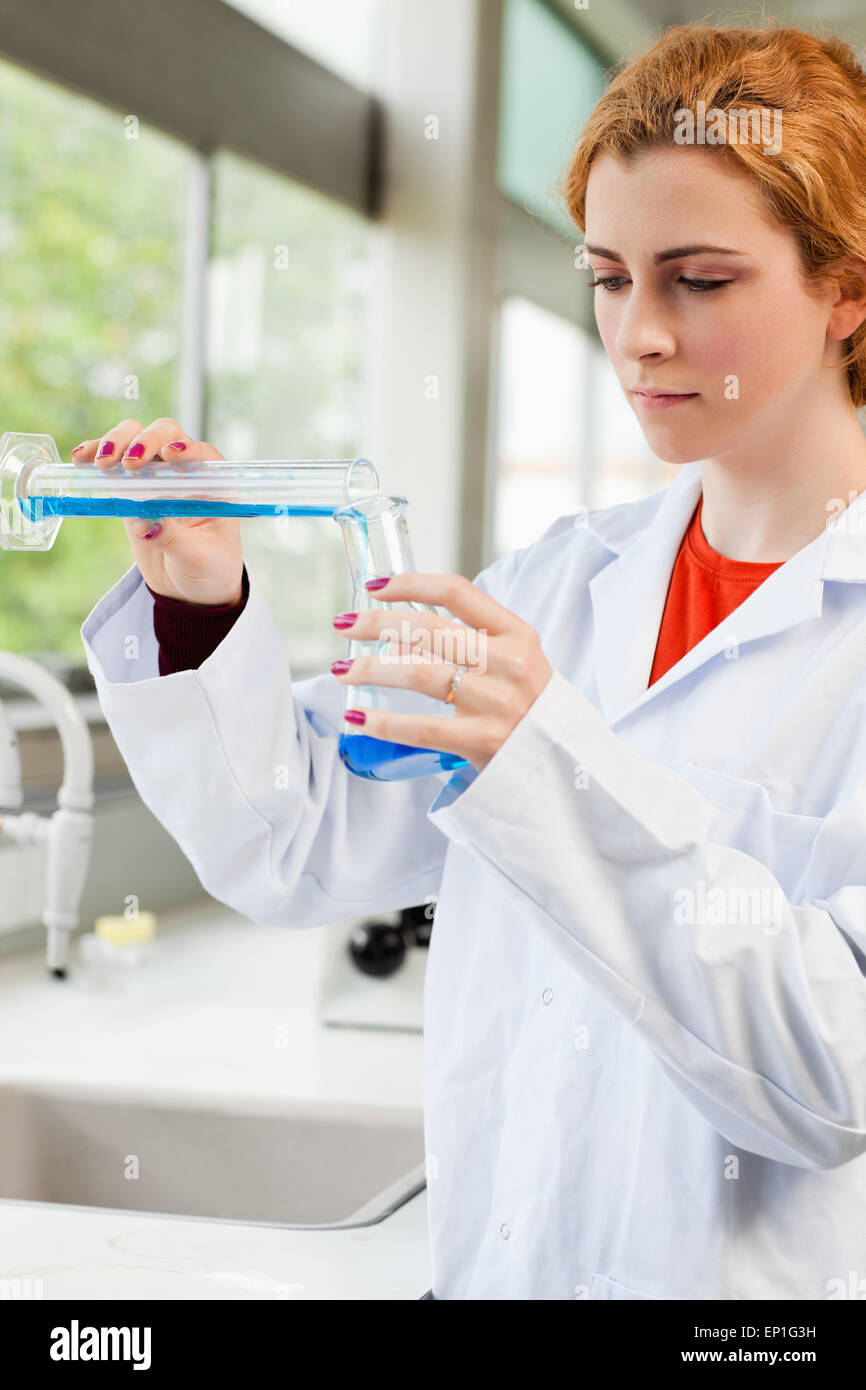 Portrait of a red-haired scientist pouring liquid Stock Photo - Alamy