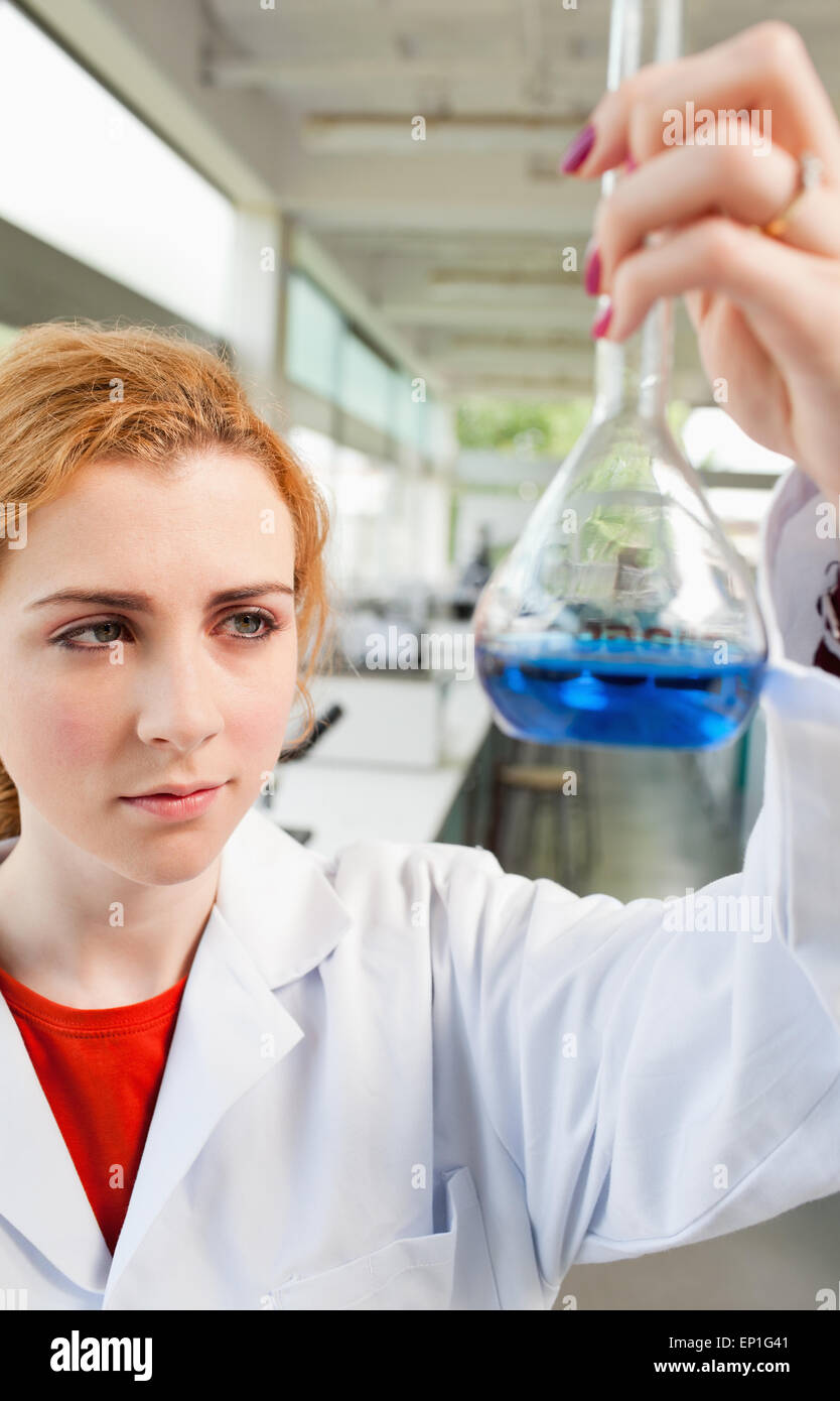 Portrait of a cute science student holding a blue liquid Stock Photo ...