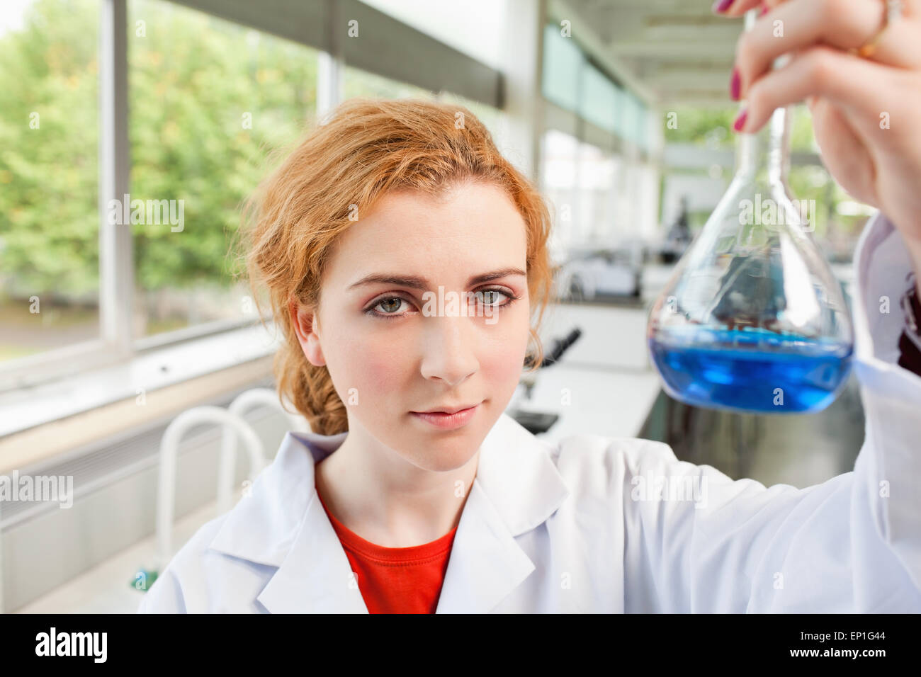 Cute science student holding a flask Stock Photo - Alamy