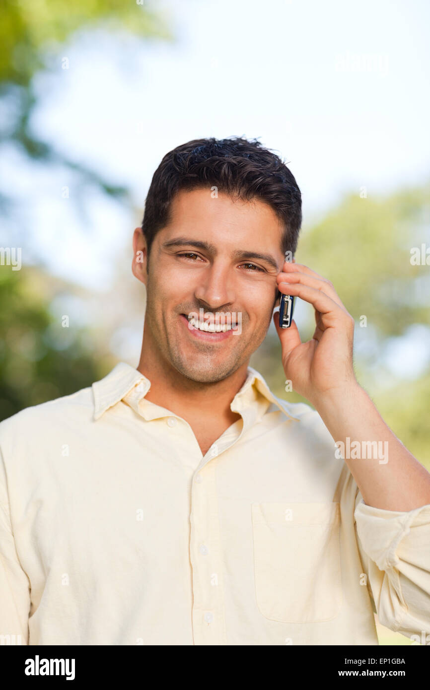 Handsome man phoning in the park Stock Photo - Alamy