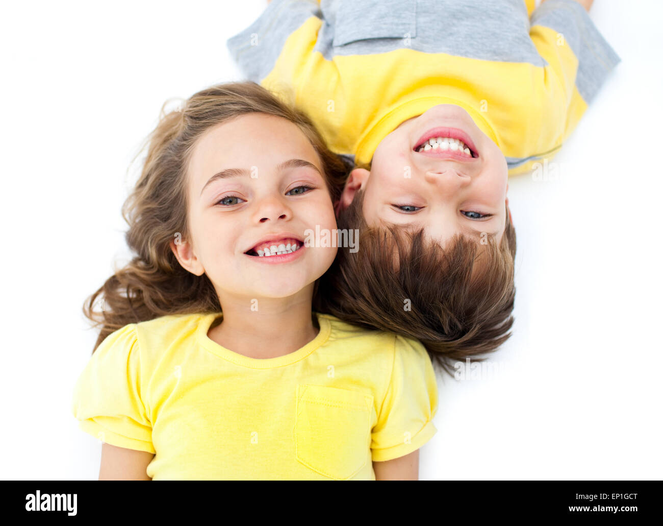 Smiling siblings lying on the floor Stock Photo - Alamy