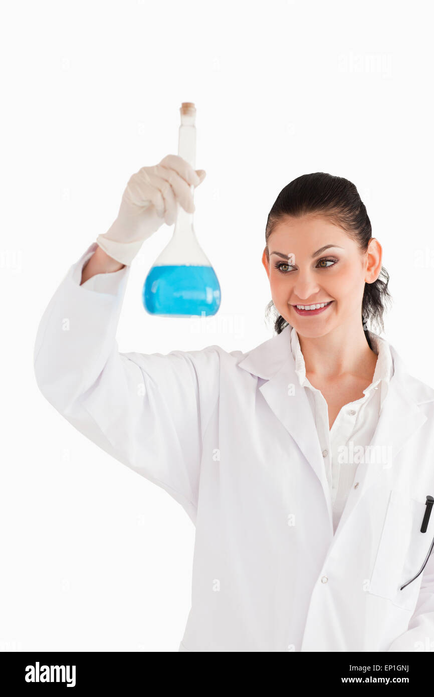 Dark-haired smiling scientist looking at a flask Stock Photo - Alamy