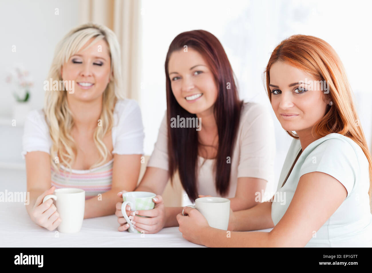 Women sitting at a table drinking coffee Stock Photo - Alamy