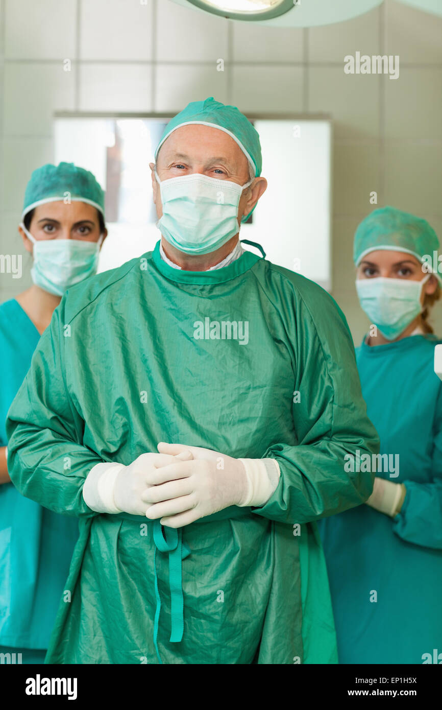 Surgeon joining his hand with interns behind him Stock Photo - Alamy
