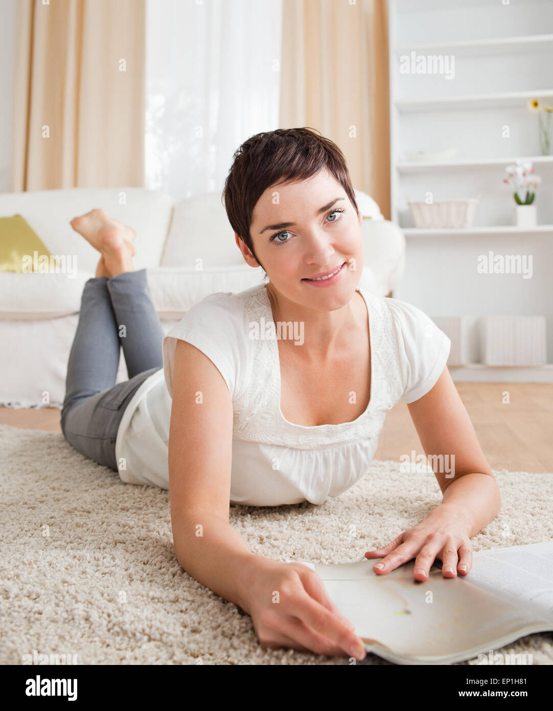 Portrait of a smiling brunette with a magazine Stock Photo - Alamy