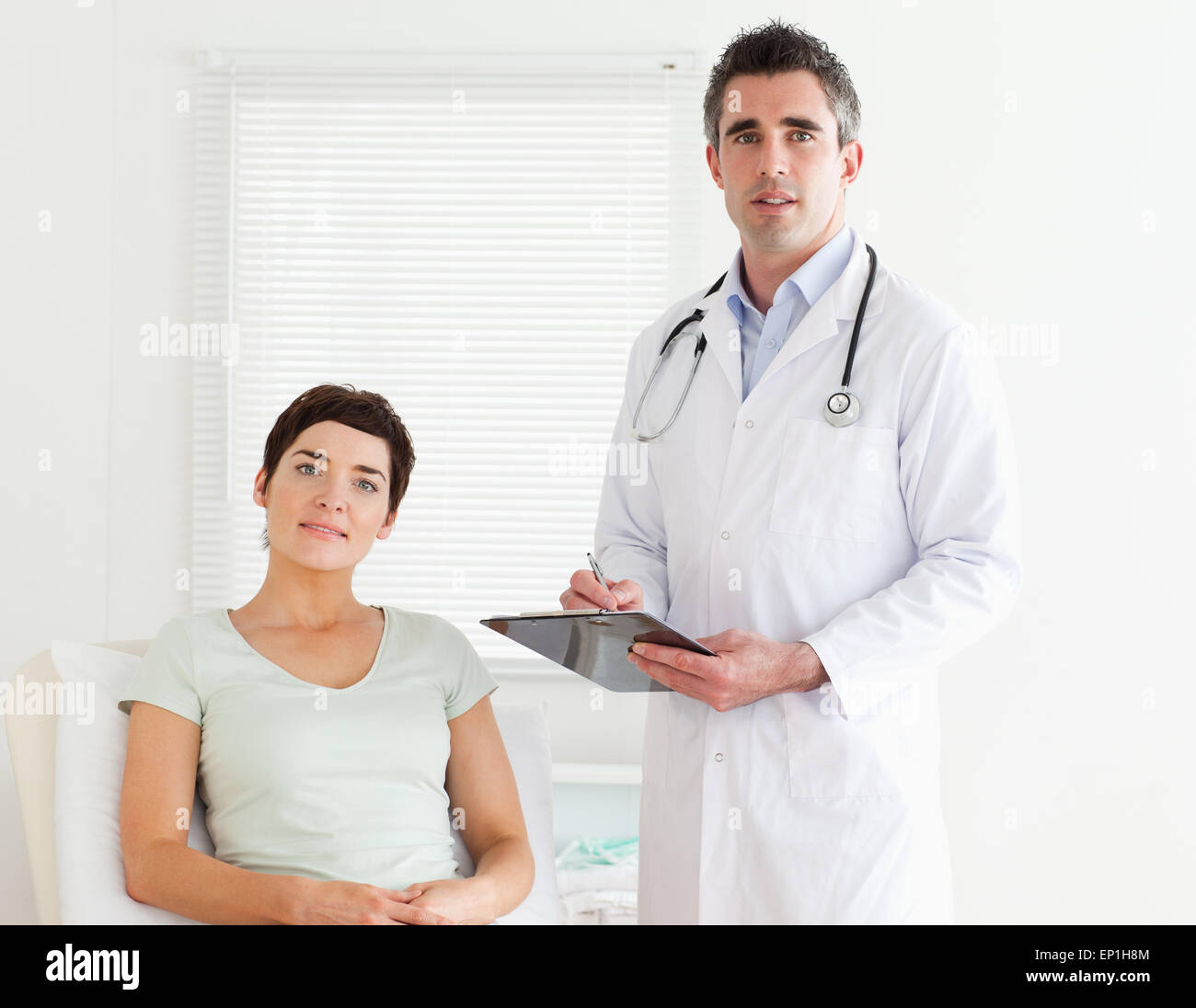 Doctor and patient looking into a camera Stock Photo - Alamy