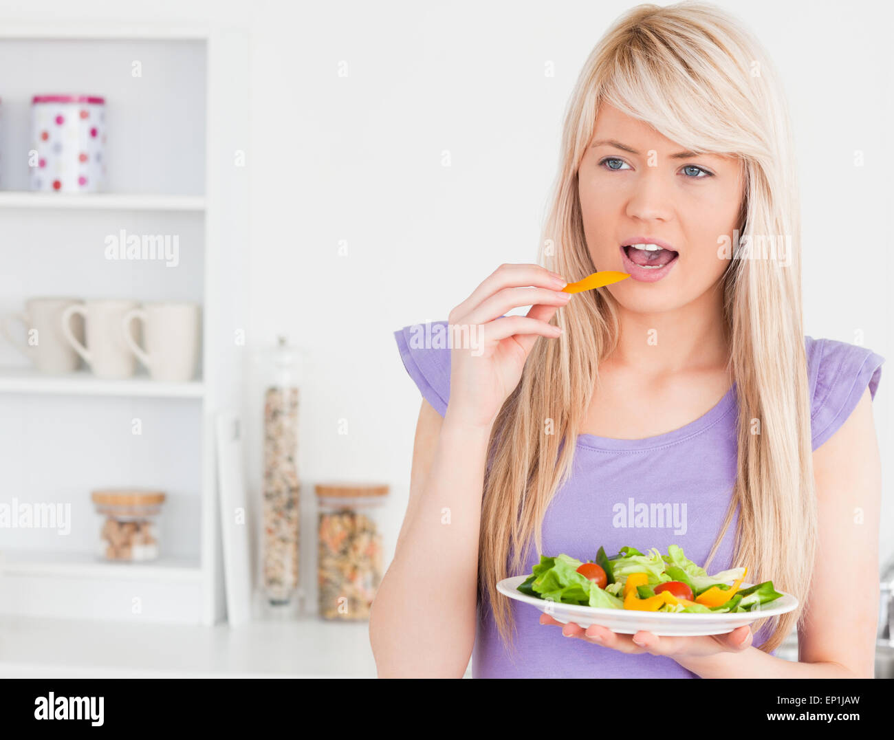 Smiling female eating her salad Stock Photo - Alamy