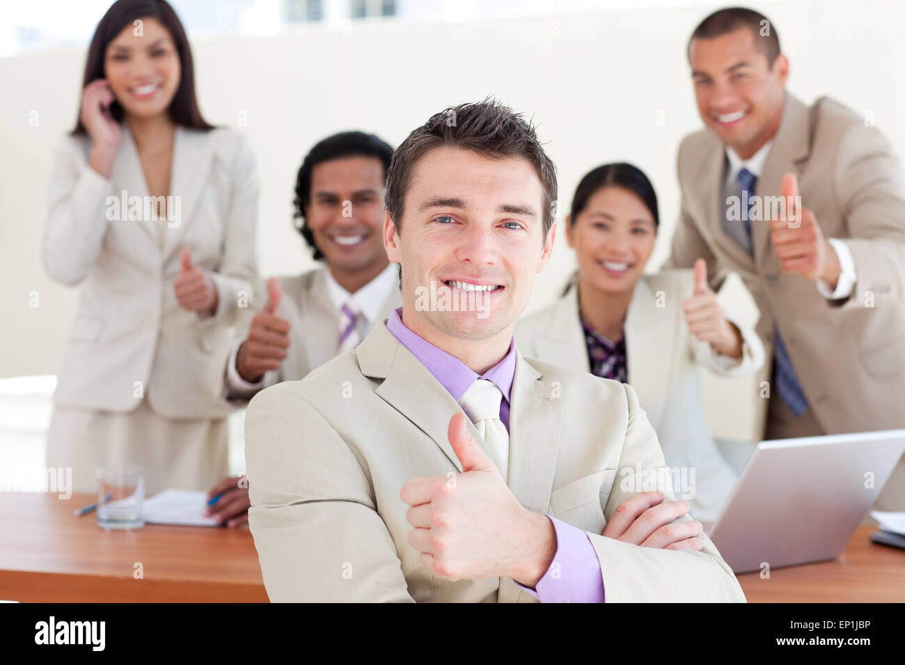 Successful manager in front of his team with thumbs up Stock Photo - Alamy