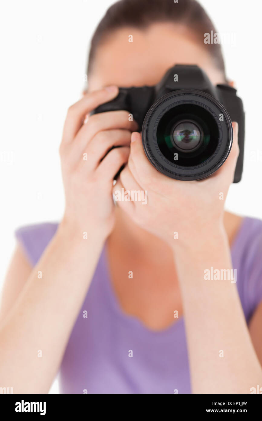 Pretty female using a camera while standing Stock Photo - Alamy